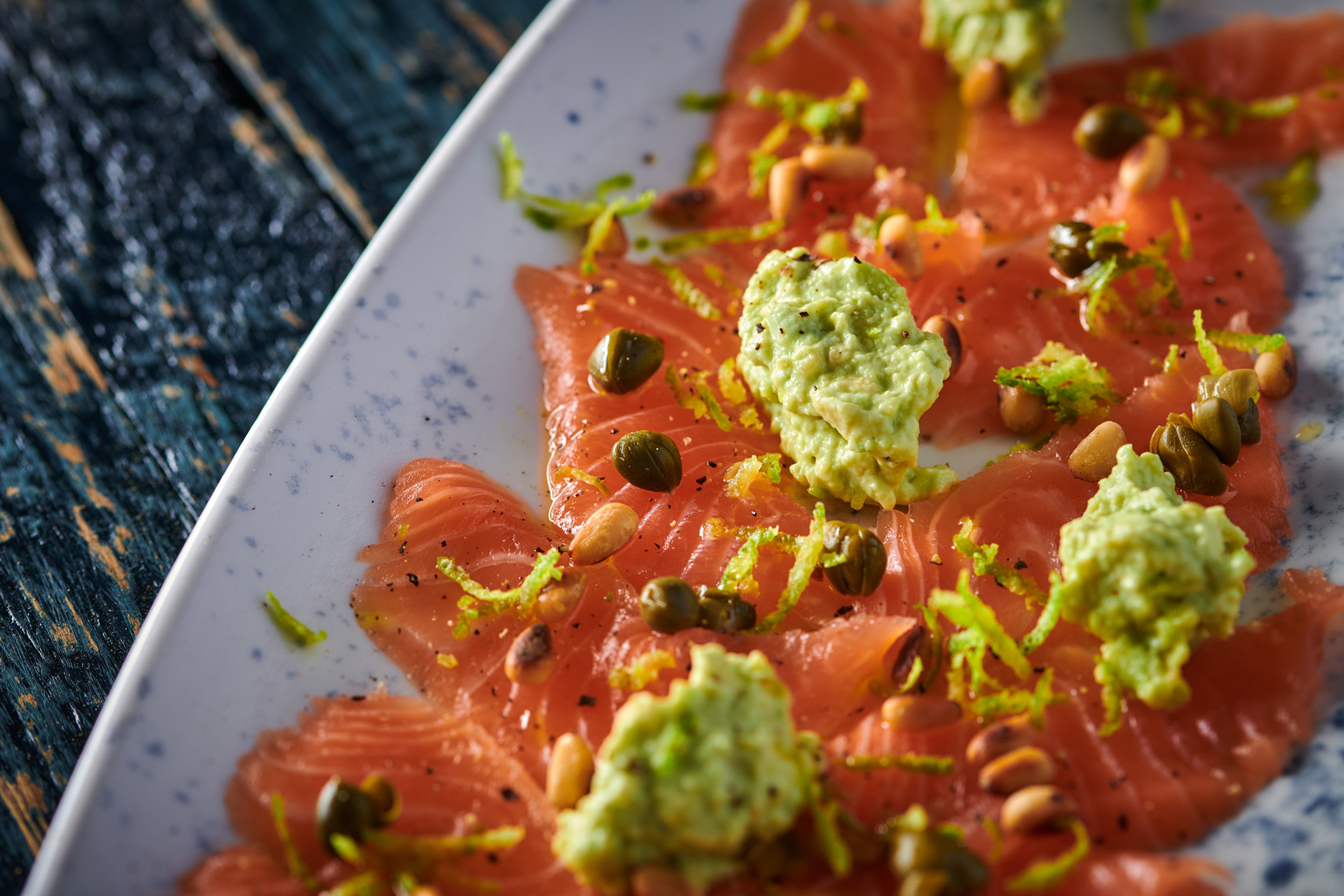 Carpaccio av laks med avokadokrem, kapers og pinjekjerner